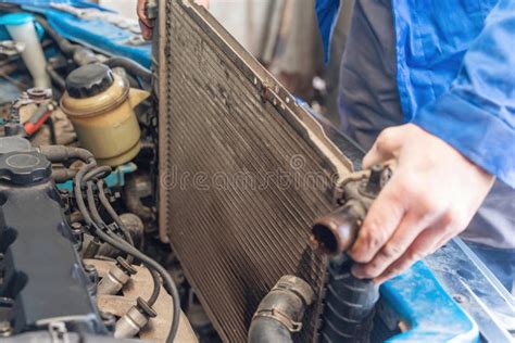 A Man Replaces An Old Broken Radiator In A Car With A New One Stock Image Image Of
