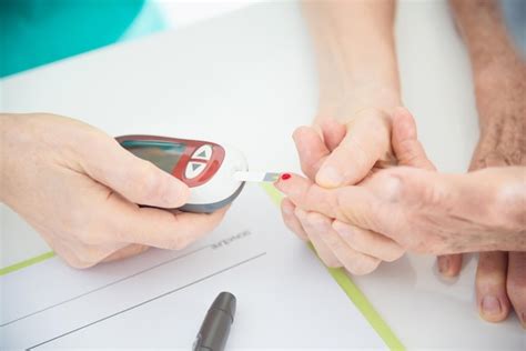 Premium Photo Cropped Hands Doing Blood Sugar Test On Table
