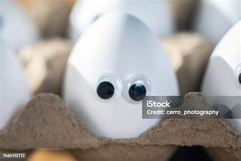 부엌 테이블에 유기농 닭고기 달걀이 있는 판지 상자에 흰 계란에 재미있는 얼굴이 클로즈업 큰 애니메이션 눈을 닫습니다 유머 음식 및 부활절 휴가 개념 0명에 대한 스톡 사진