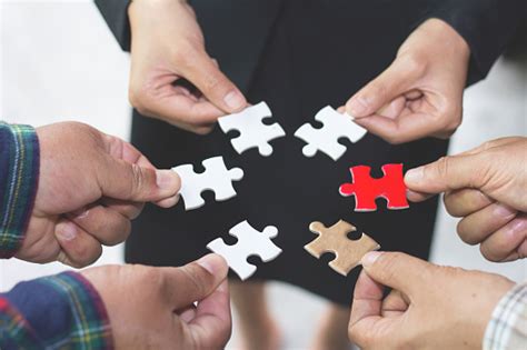 캐주얼 체크 무늬 셔츠를 입고 하는 기업 들의 손에 종이 직소 퍼즐 고 해결 퍼즐 직소 퍼즐 퍼즐의 조각을 함께 넣어 하 고 싶은 비즈니스 그룹을 조립 하는 비즈니스 팀