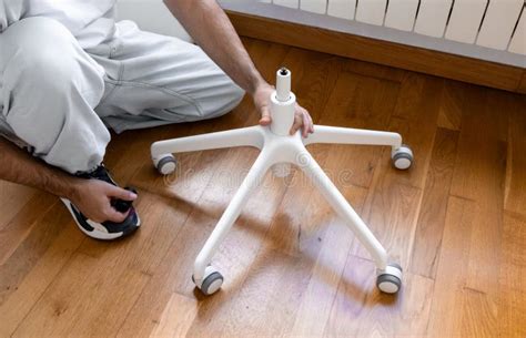 Assembling Office Chair Base On Wooden Floor With Caucasian Male