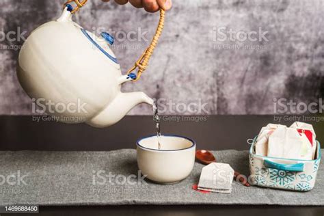 차를 준비하기 위해 뜨거운 물을 붓는 동안 주전자를 들고 있는 손과 다양한 종류의 차가 담긴 여러 봉지를 클로즈업합니다 0명에 대한 스톡 사진 및 기타 이미지 Istock