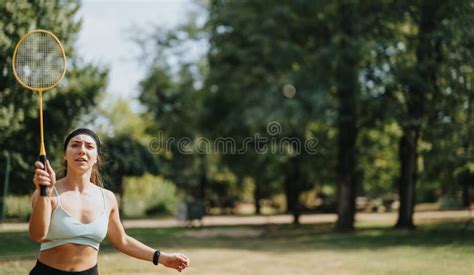 Attractive Young Girls Having Fun Playing Badminton In The Park On A
