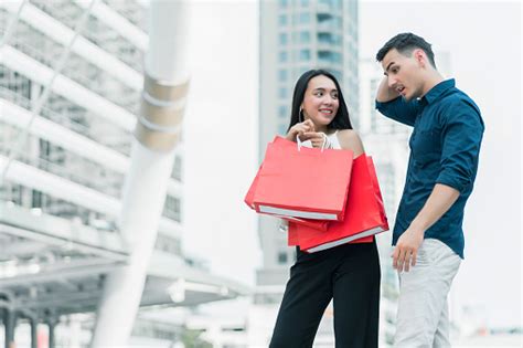 야외에서 쇼핑 봉투와 함께 행복 한 커플입니다 아내 게 그녀의 남편 구매에 놀 랐 다 비즈니스 쇼핑 구매자 소비자와 매력적인 애 인의 개념 2명에 대한 스톡 사진 및 기타