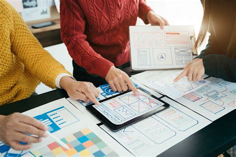 Ui 디자이너가 사무실에서 고객 브리프와 색상 코드를 사용한 모바일 앱 인터페이스 와이어프레임 디자인에 대해 브레인스토밍합니다 2명에 대한 스톡 사진 및 기타 이미지