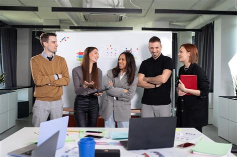 Tres Chicas Y Dos Chicos Posan Para La Cámara En La Oficina Foto Del