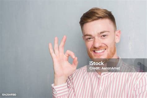 손가락 우수한 기호 확인 표시를 하 고 회색 그런 지 벽에 빨강 머리 젊은 남자 개념에 대한 스톡 사진 및 기타 이미지 개념 개념과 주제 그런지 이미지 기법 Istock