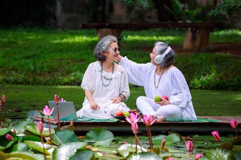 Senior Women Sharing A Tender Moment By Lotus Pond Stock Photo Image Of Affection Exploration