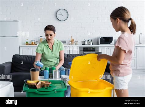 Woman Sorting Cans Near Blurred Babe And Trash Bins At Home Stock Photo Alamy