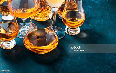 코냑 스카치 위스키 등 강력한 알코올 음료 하드 주류 증류주 및 증류소 이셋을 안경에 넣고 있습니다 파란색 배경 상단 보기 광고에 대한 스톡 사진 및 기타 이미지 Istock