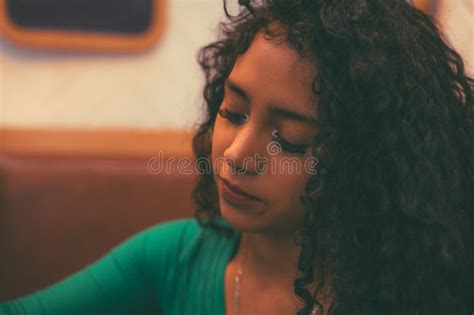 Curly Haired Brunette Girl Enjoys A Cup Of Coffee In A Cafe Besides