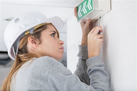 Woman Screwing Directional Exit Sign To Wall Stock Photo Image Of Green Directional 331786892