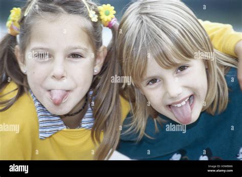 Girls Two Gesture Cheeky Tongue Stick Out Portrait Outside Stock