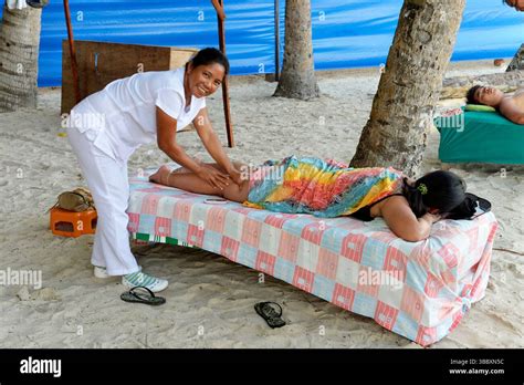 Tourist Receiveing Beach Massage From Philippina Woman On Alona Beach At Panglaobohol Island