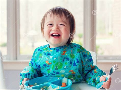 Niño Pequeño Que Come La Comida Con Una Bifurcación Imagen De Archivo Imagen De Babero Risa