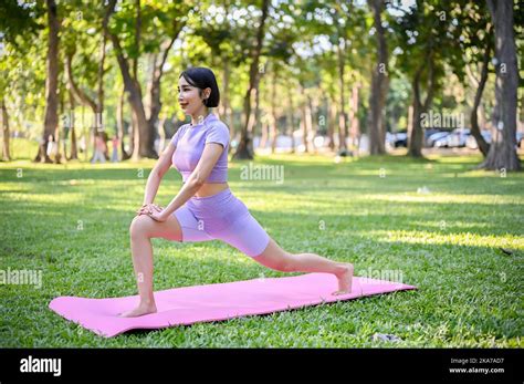 Healthy And Charming Young Asian Woman In Sportswear Stretching Her