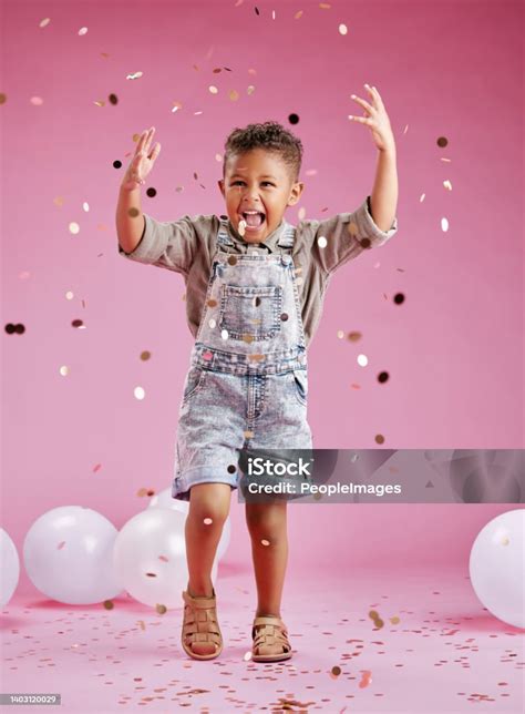 스튜디오에서 분홍색 카피 스페이스 배경을 축하하고 승리하는 귀여운 작은 혼합 레이스 소년 색종이와 풍선으로 성별 공개 파티에 흥분하는 아프리카 어린이 행복에 대한 스톡 사진