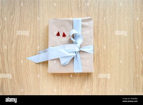Christmas T Parcel Wrapped In Brown Paper And Tied Up With A Blue