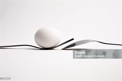 금속 포크에 달걀을 히켄 흰색 배경 클로즈업에 격리 된 숟가락 두 포크 숟가락 위에 놓인 달걀 계란은식이 요법에서 베이킹 조리법에 이르기까지 많은 용도로 사용됩니다 단백질에