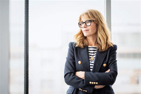 사무실에서 팔짱을 끼고 서 있는 동안 신중하게 바라보는 경영자 사업가 여자 사업가에 대한 스톡 사진 및 기타 이미지 여자 사업가 정식 인물사진 먼 곳을 바라봄