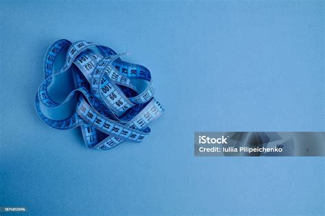 파란색 배경에 파란색 줄자 길이와 부피를 측정하기 위한 도구 의류 산업 또는 인체의 부피를 측정하기 위한 테이프 0명에 대한