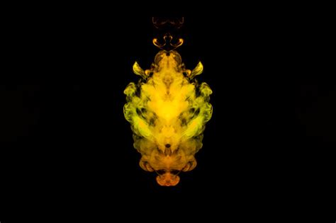 검은 고립 된 배경에 머리 얼굴과 눈의 모양에 공포의 형태로 다른 녹색 노란색 오렌지와 붉은 색의 연기의 추상적 인 이미지 신비한 상징의 영혼과 유령 0명에 대한 스톡 사진