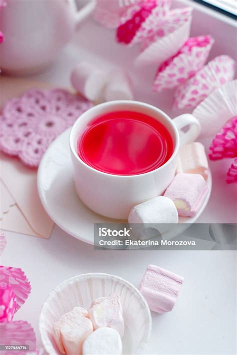 다채로운 종이 깃발 천와 마 시 멜로 과자와 흰색 배경에 앉아 핑크 향기로운 차와 접시 화이트 티 컵 0명에 대한 스톡 사진 및