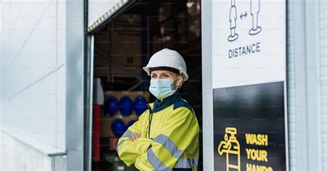 창고 앞에 서 있는 얼굴 마스크를 쓴 여성 노동자의 초상화 코로나바이러스 개념 사진 Unsplash의 보호 작업복 이미지