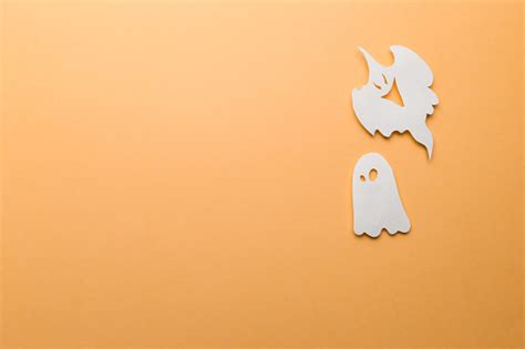 할로윈 장식 오렌지 배경에 할로윈 종이 장식입니다 맨 위 보기 액세서리 장식 할로윈 축제의 플랫 레이 공간을 복사합니다 최소한의 창조적 인 개념 파스텔 색상 10월에 대한
