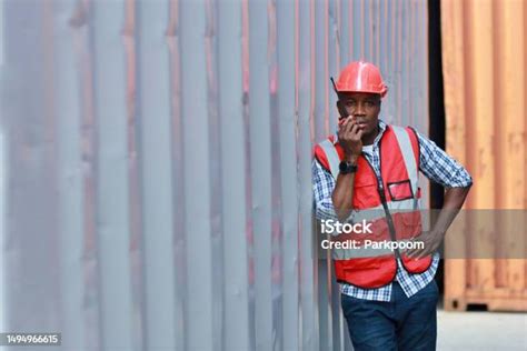 태블릿과 워키토키 무선 조종 적재 컨테이너 상자를 사용하는 감독 안전모를 쓴 엔지니어 또는 작업자는 컨테이너 화물 현장에서 작업하고 산업용 컨테이너 화물 화물선을 점검합니다