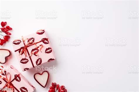성 발렌타인 데이 개념 복사 공간이 있는 격리된 흰색 배경에 키스 입술 패턴과 하트 모양의 양초가 있는 포장지에 있는 선물