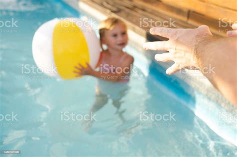 초점이 흐려진 귀여운 행복한 백인 금발 2세 소녀 어린이 어린이 유아가 여름 수영장에서 야외에서 즐거운 시간을 보내는 성인과 함께 발 놀이를 하고 있습니다 부주의 한 어린