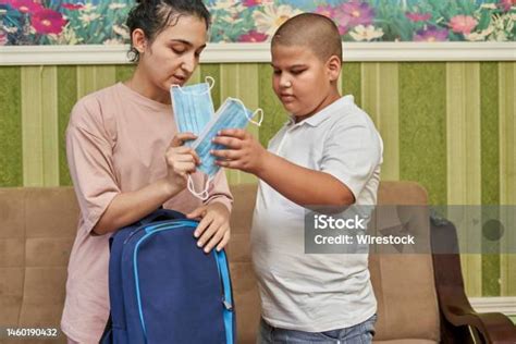 학교에 가기 전에 어린 학생의 배낭에 의료용 안면 마스크를 넣는 성인 2명에 대한 스톡 사진 및 기타 이미지 2명 건강관리와 의술 공부 Istock