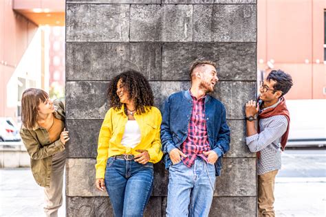 대학 캠퍼스 벽에서 즐거운 시간을 보내는 다민족 친구들 도시 밖에서 축하하는 다양한 문화 학생들 캠퍼스 안뜰에서 함께 노는 웃는 젊은 친구들 20 24세에 대한 스톡 사진