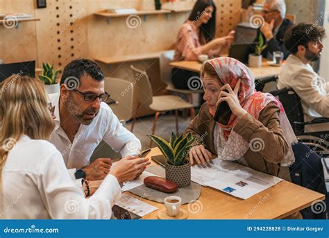 Muslim Female Employee Wearing Hijab Having Phone Call And Listening To