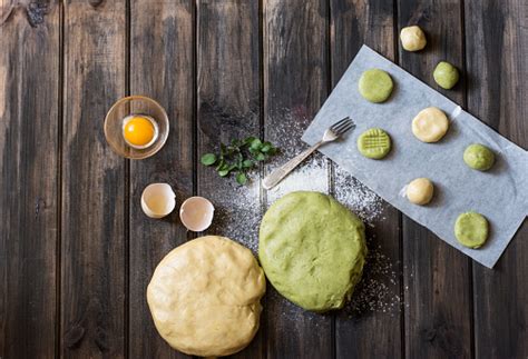 원시 민트와 오렌지 나무 테이블에 쿠키 칩 반죽 색깔 민트 쿠키입니다 오렌지 쿠키입니다 굽기의 과정입니다 수 제 빵집입니다 원시 쿠키입니다 새 해 개념입니다 감귤류 과일에