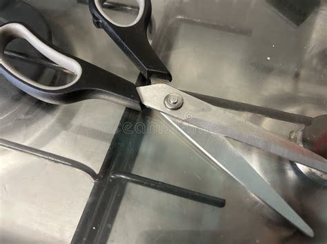 Scissors On A Glass Surface Black And Silver Design Stock Image