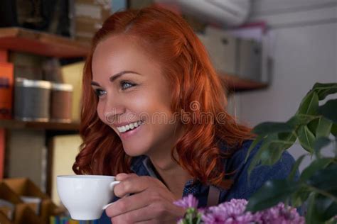 A Beauty Redhead Girl Drinks Coffee Sitting Near The Coffee Shop