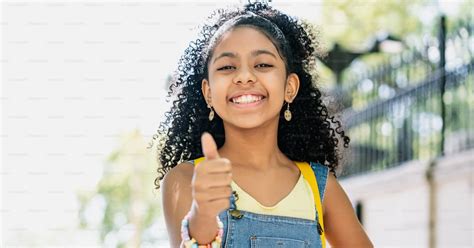 아프리카계 미국인 어린 소녀는 거리에서 배낭을 메고 웃고 엄지손가락을 치켜들고 있습니다 교육 개념입니다 사진 Unsplash의 엄지손가락 이미지