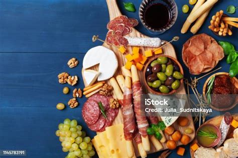 나무로 되는 주방 테이블 평면도에 미식 음식이 포함 된 이탈리안 전채 요리 또는 안티파스 토 치즈와 육류 스낵의 혼합 된 델리 카트 슨 레드 와인 0명에 대한 스톡 사진 및