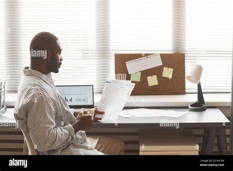 Minimal Side View Portrait Of Black Entrepreneur Analyzing Data While