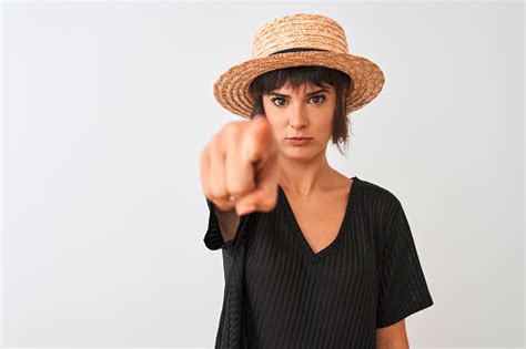 검은 색 티셔츠와 모자를 쓰고 카메라와 당신에 게 손가락으로 가리키는 고립 된 흰색 배경 위에 서 젊은 아름 다운 여자 손 기호 앞에서 긍정적이 고 자신감 제스처 T 셔츠에