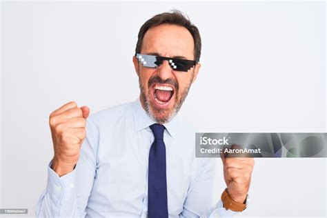 고립 된 흰색 배경 위에 깡패 생활 선글라스를 착용 중년 사업가는 매우 행복하고 팔을 들고 미소와 성공을 위해 비명을 지르는 우승자 제스처를하고 흥분 축 하 개념입니다