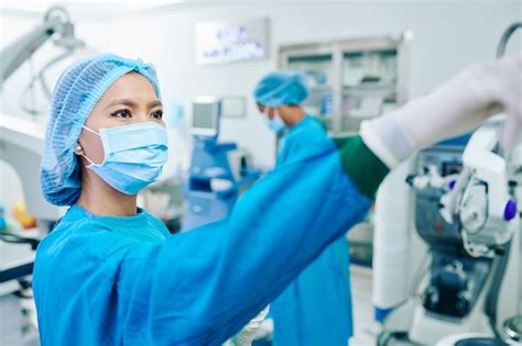 Premium Photo Surgeon Assistant Turning On Equipment In Operating Room