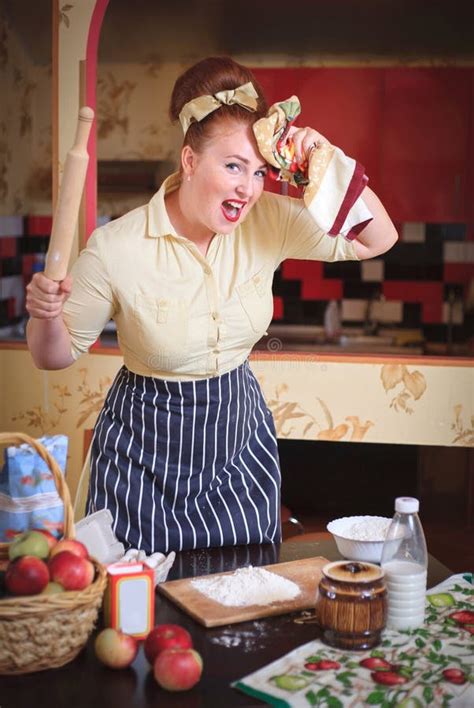 Emotional Expressive Woman In The Kitchen In The Hands Holding Tools For Cooking Food Stock