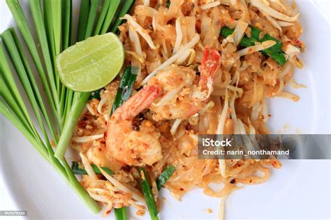 패드 태국어 볶음된 쌀 국수와 흰 접시에 새우와 레몬과 녹색 야채 슬라이드 태국의 국가 메인 요리 중 하나입니다 태국에서 인기 있는 음식 태국 볶음 국수 0명에 대한 스톡