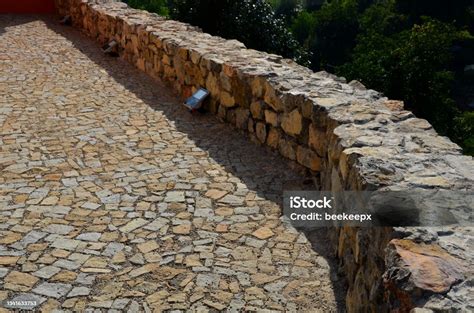 시멘트 박격포와 결합 거친 돌의 아름답게 접힌 옹벽 갈색 베이지 색 노란색 불규칙한 석회암 돌 그 위에 경사를 들고 물 배수 파이프는 벽에서 멀리 리드 갈색에 대한 스톡