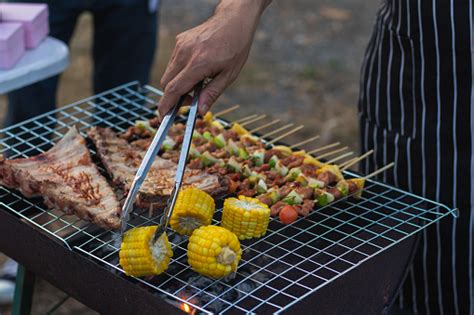 바베큐 파티를 위한 고기와 꼬치 재료를 그릴에 올려 바베큐를 요리하고 오늘 밤 가족이 바베큐 파티에 참여할 수 있도록 준비합니다 파티 배경 이미지에는 텍스트에 대한 복사