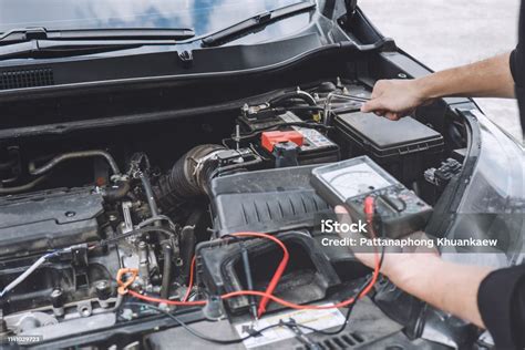 서비스 자동차 엔진 기계 개념 자동차 정비사 수리 손은 렌치와 디지털 멀티 미터 테스트 배터리 자동차 서비스 및 유지 보수와 자동차 엔진 자동차 워크샵을 복구 가득 찬에