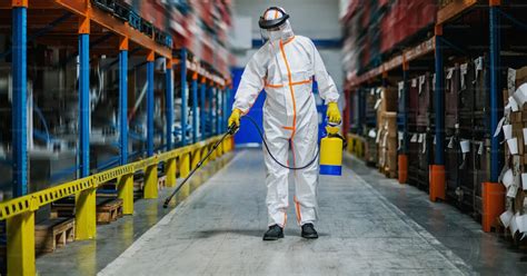 보호 마스크를 쓴 남자 노동자의 전면 모습과 스프레이 건으로 산업 공장을 소독하는 양복 사진 Unsplash의 시허하이트 이미지